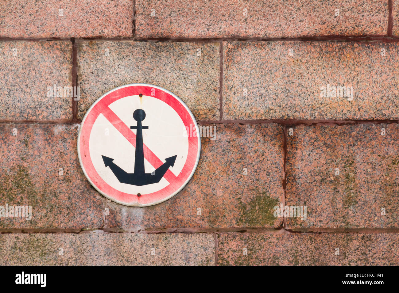 Prohibiting sign "Do not throw anchors" on granite wall of embankment ...