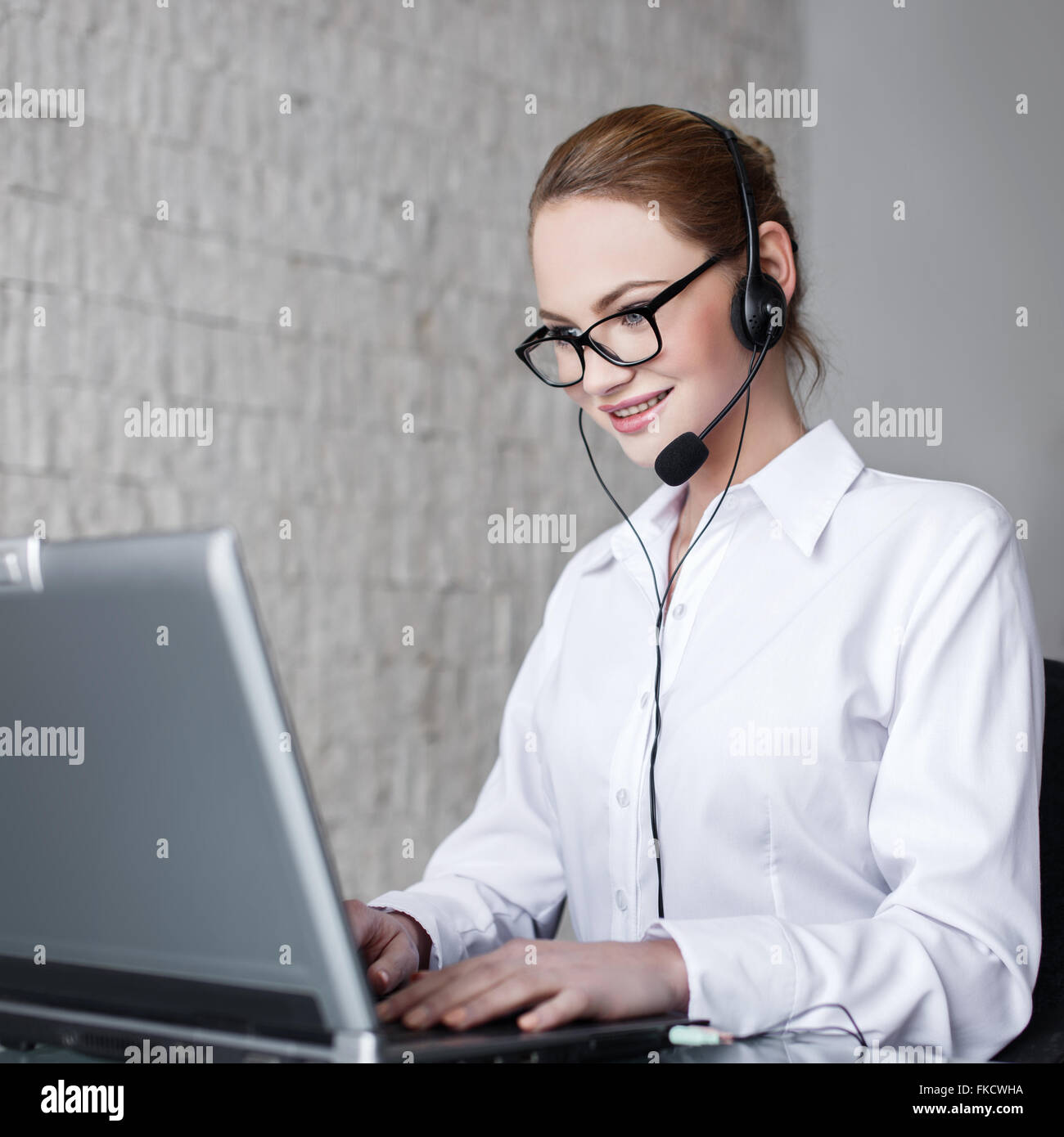 Casual customer support worker in office with headset and laptop Stock ...