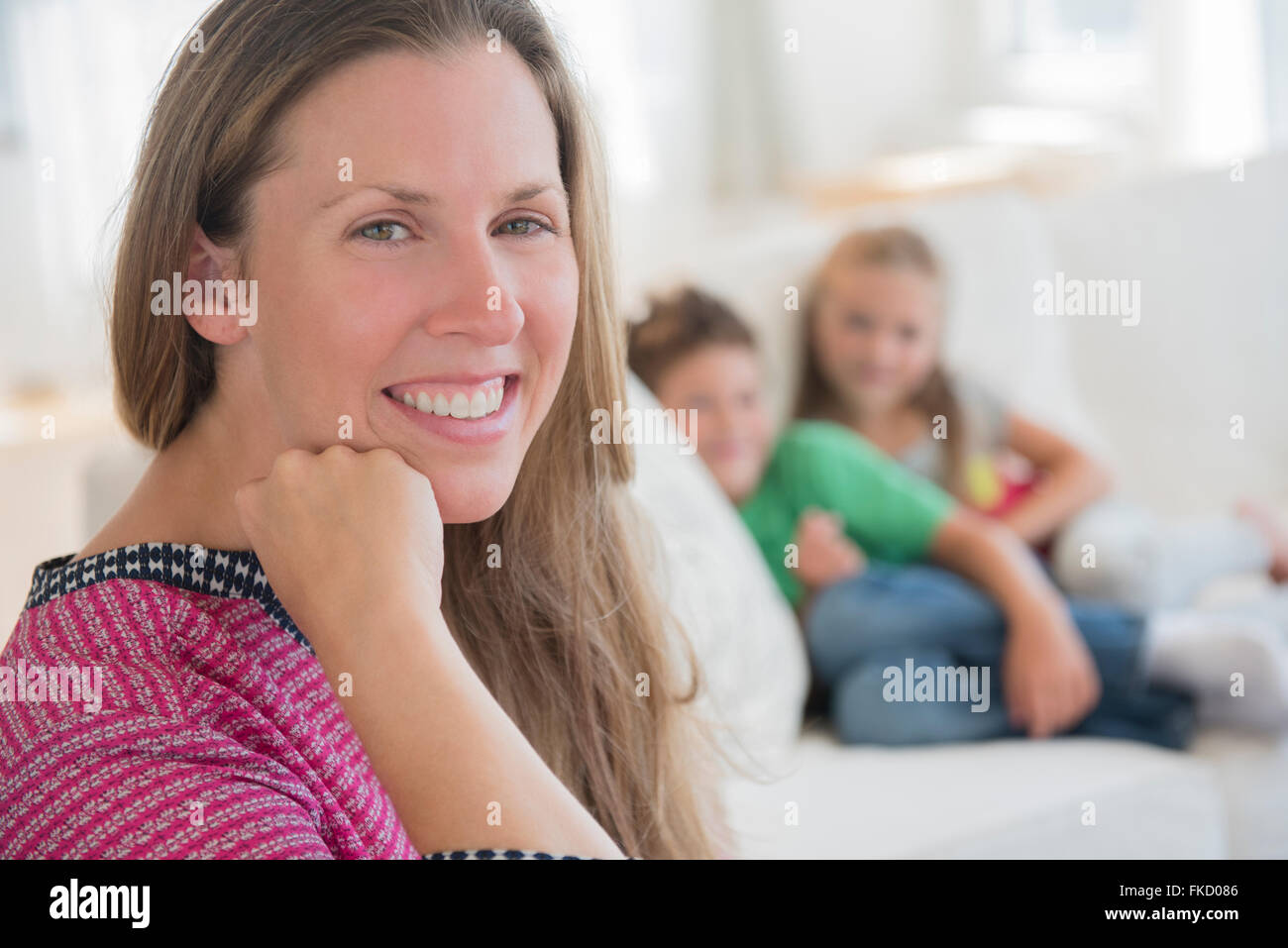 Portrait of mid adult woman with children (6-7, 8-9) in background ...