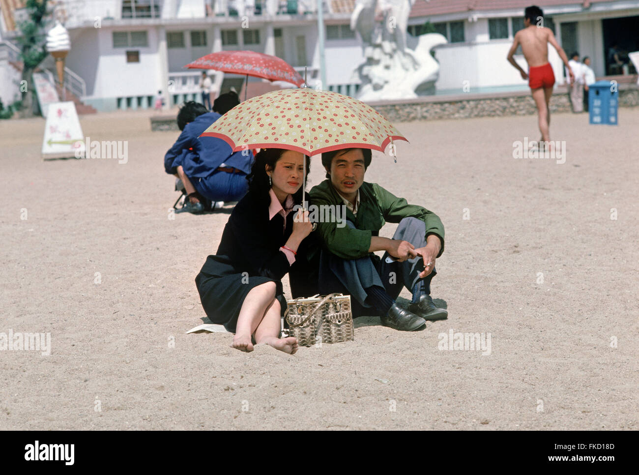 Chinese holiday makers under sun umbrellas on Qingdao beach, Sandong ...
