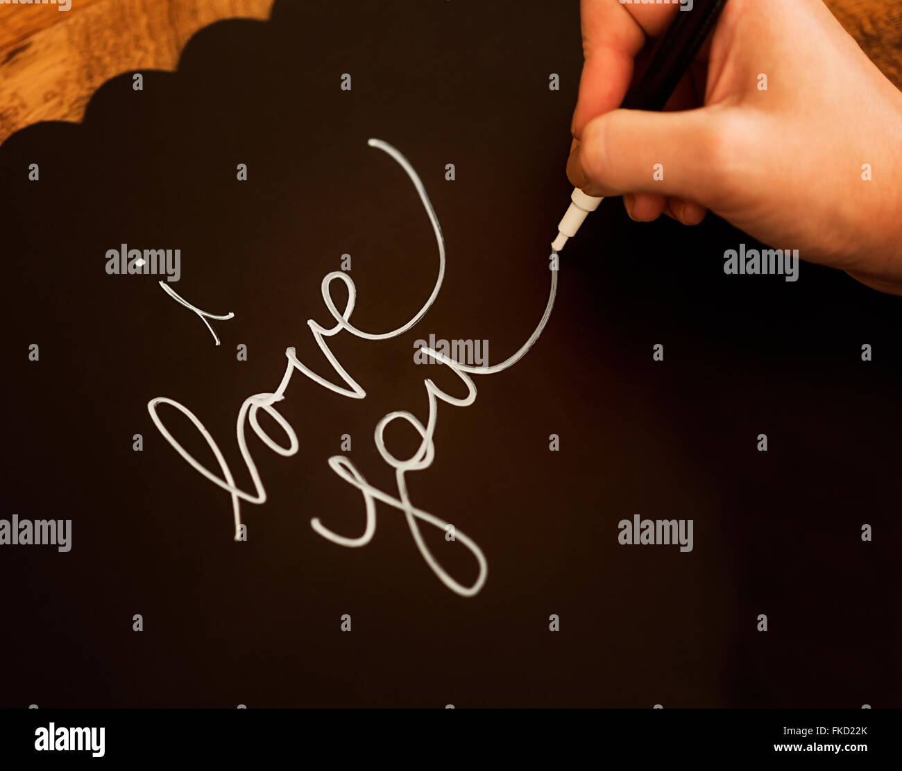 Man's hand writing I Love You on black paper Stock Photo - Alamy