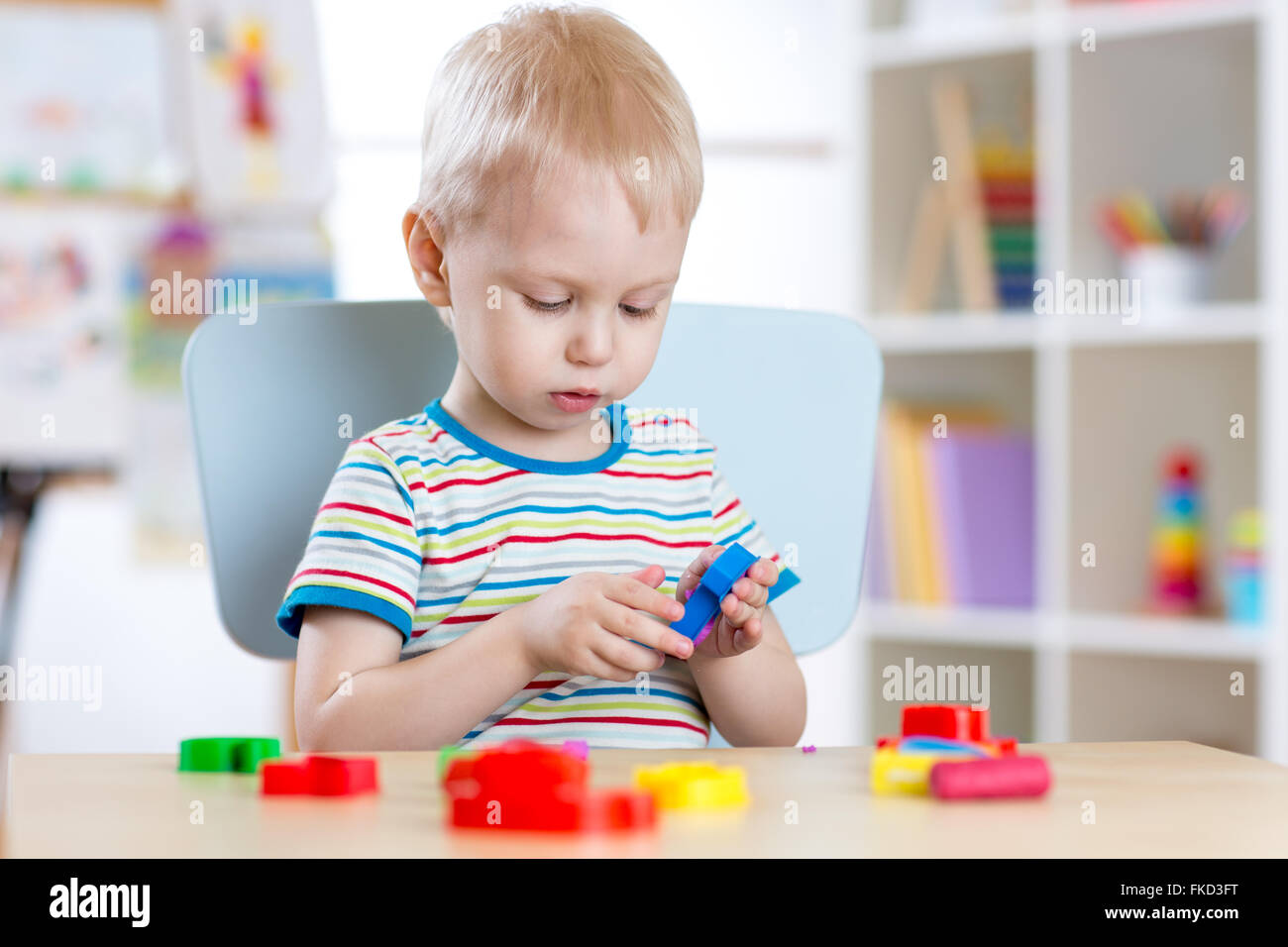 Child boy learning to use colorful play clay in nursery room Stock ...