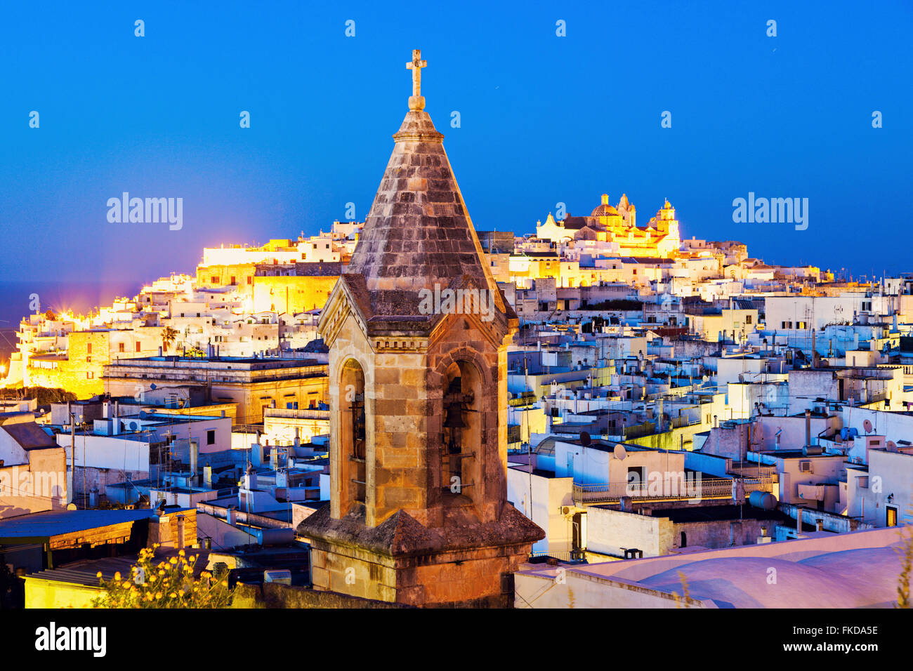 Illuminated townscape with church tower in foreground at dusk Stock ...