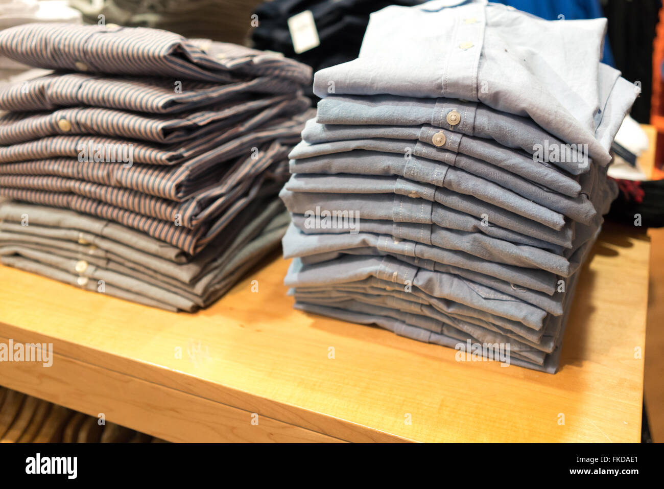 Stack of shirts in clothes shop Stock Photo - Alamy