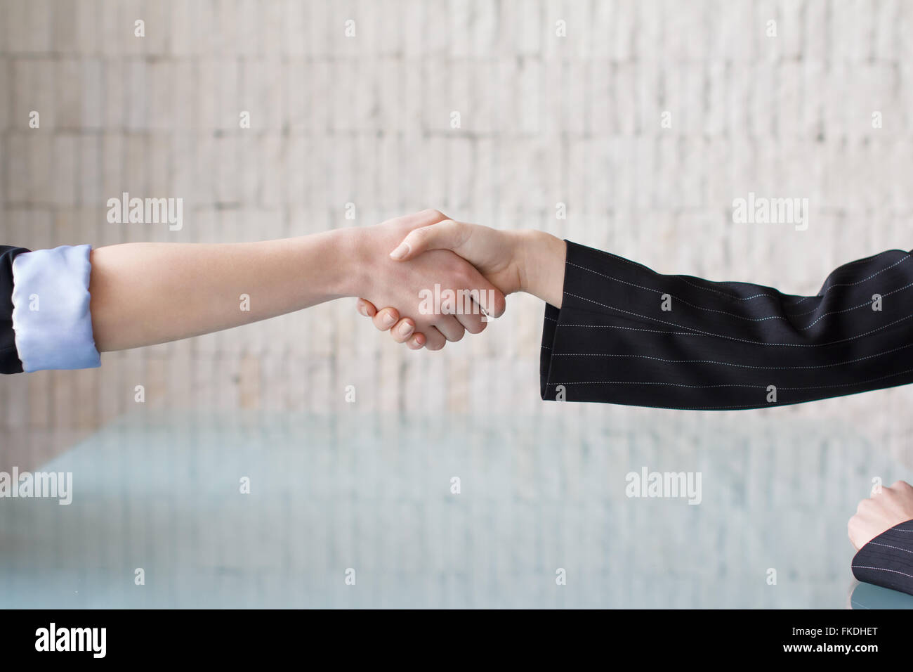 Businesswomen handshake over table hi-res stock photography and images ...
