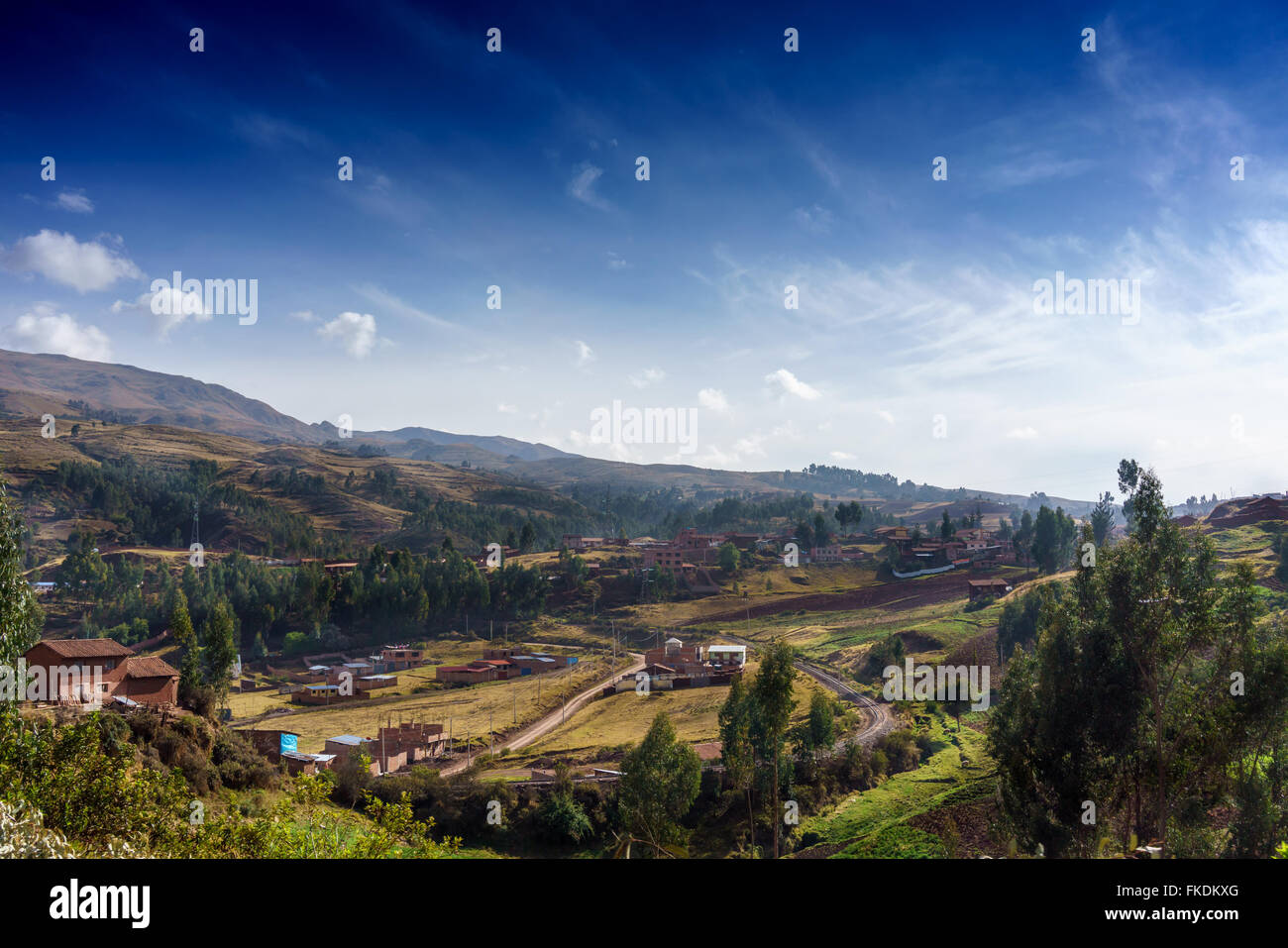 Village on hill with mountain in background against cloudy sky, Cusco ...