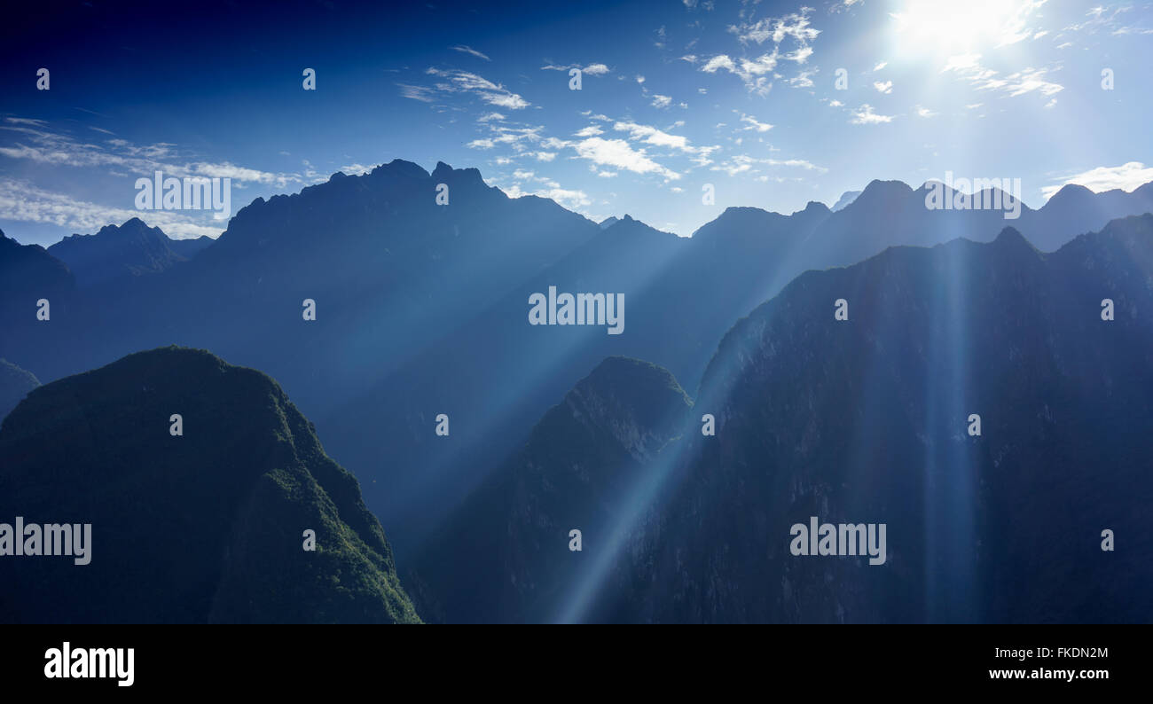 Sun rays seen in early morning over the mountains, Machu Picchu, Cusco ...
