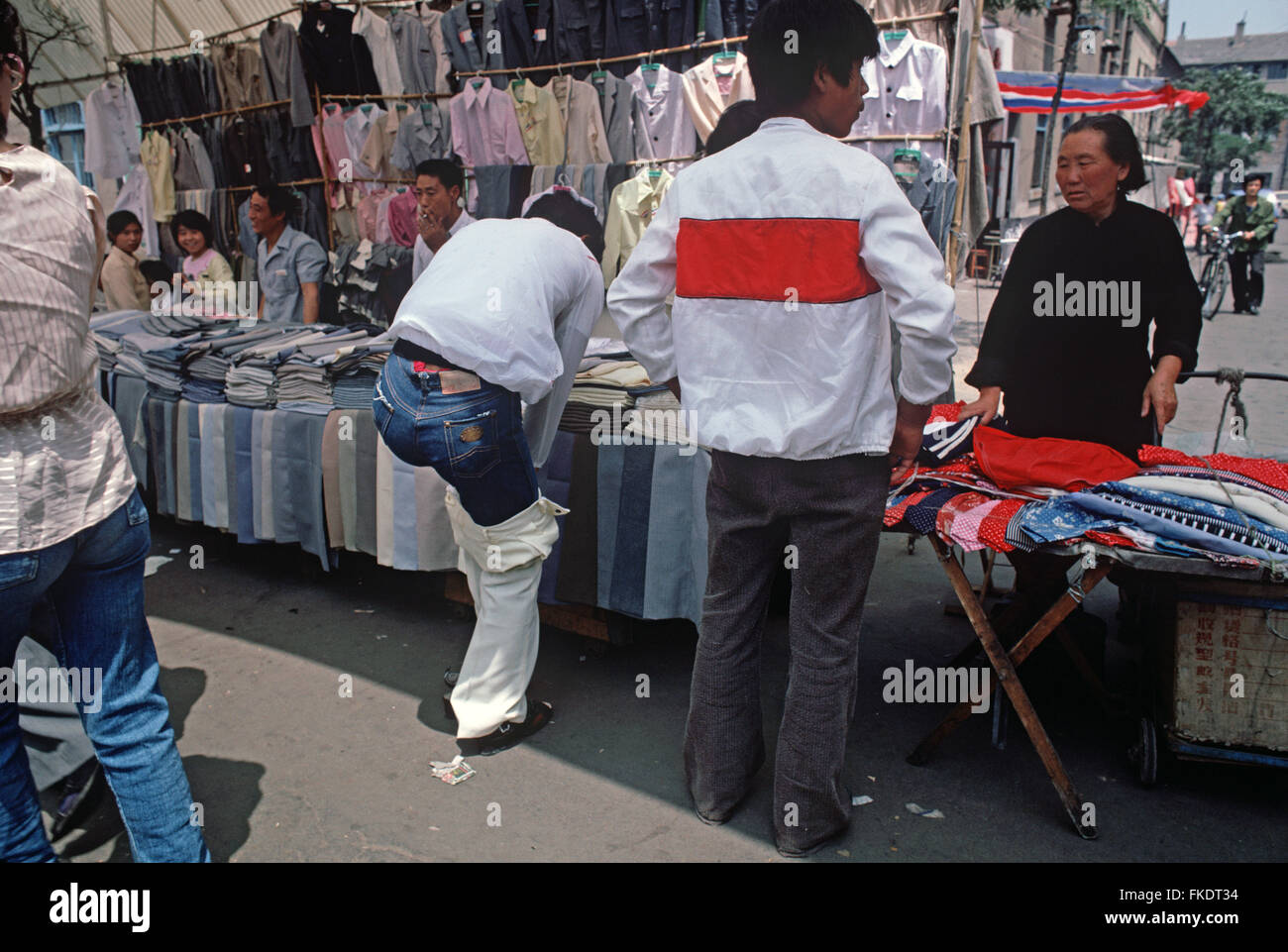 customer trying on trousers in Qingdao market clothes stall, Qingdao ...