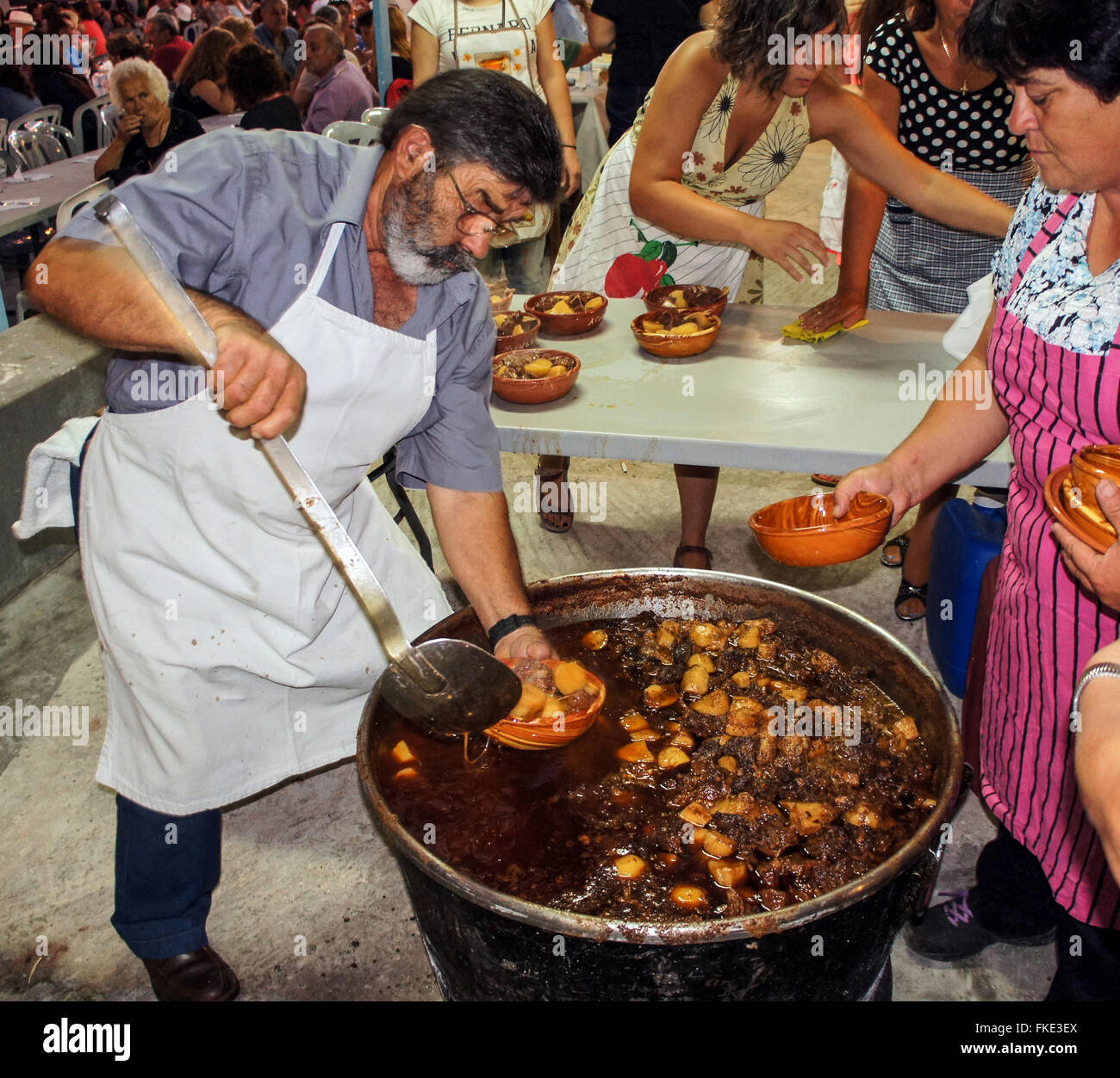 Serving meals from a big cauldron Stock Photo - Alamy