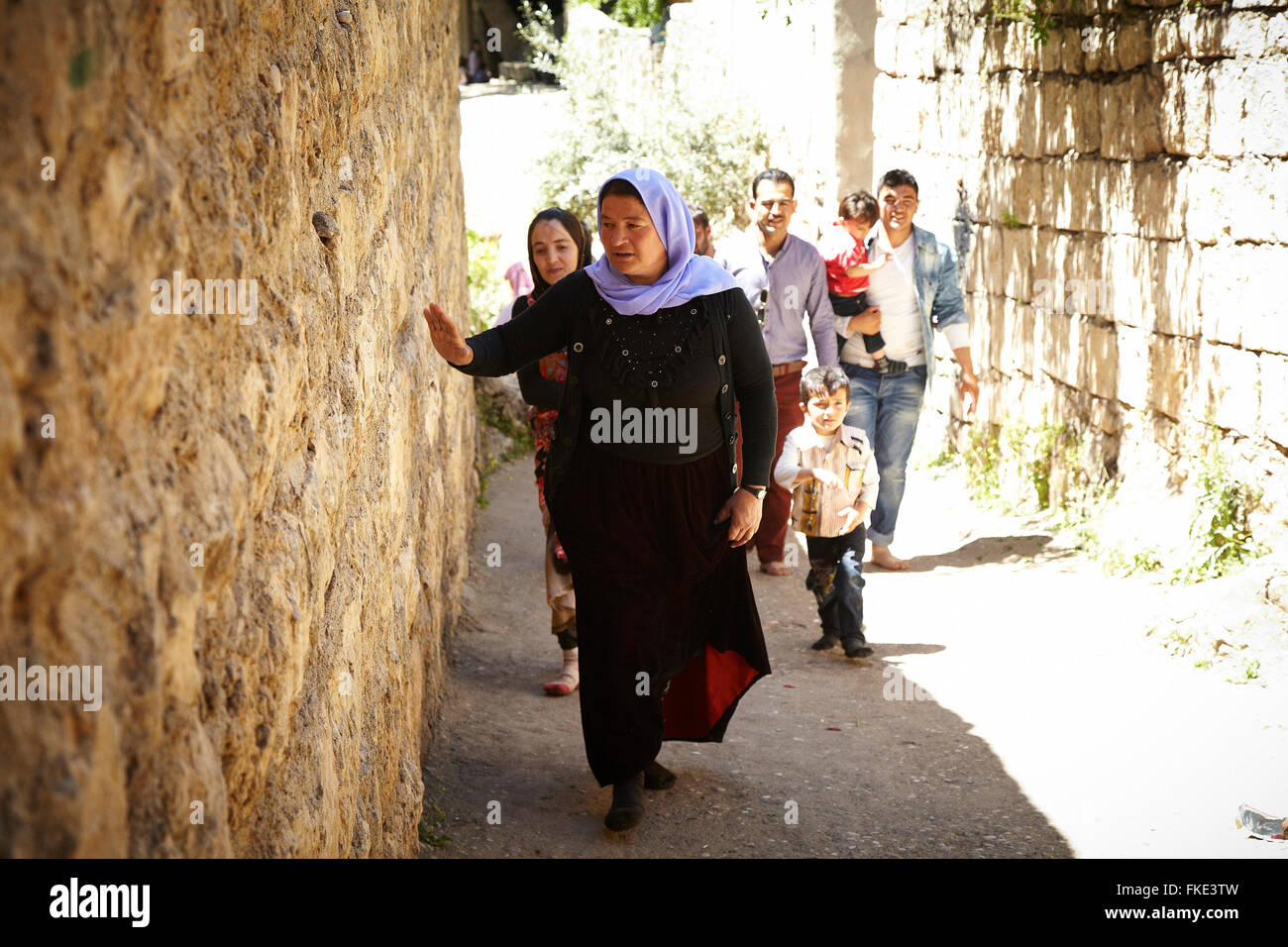 A woman preparing to touch a wall inside the Yazidi holy temple in ...