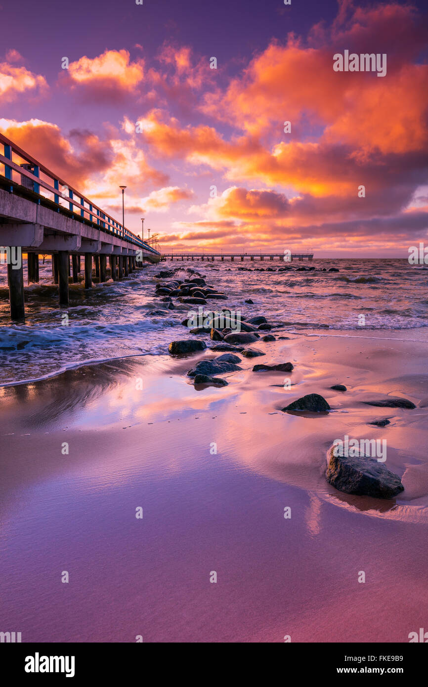 Pier and sea at pink sunset Stock Photo - Alamy