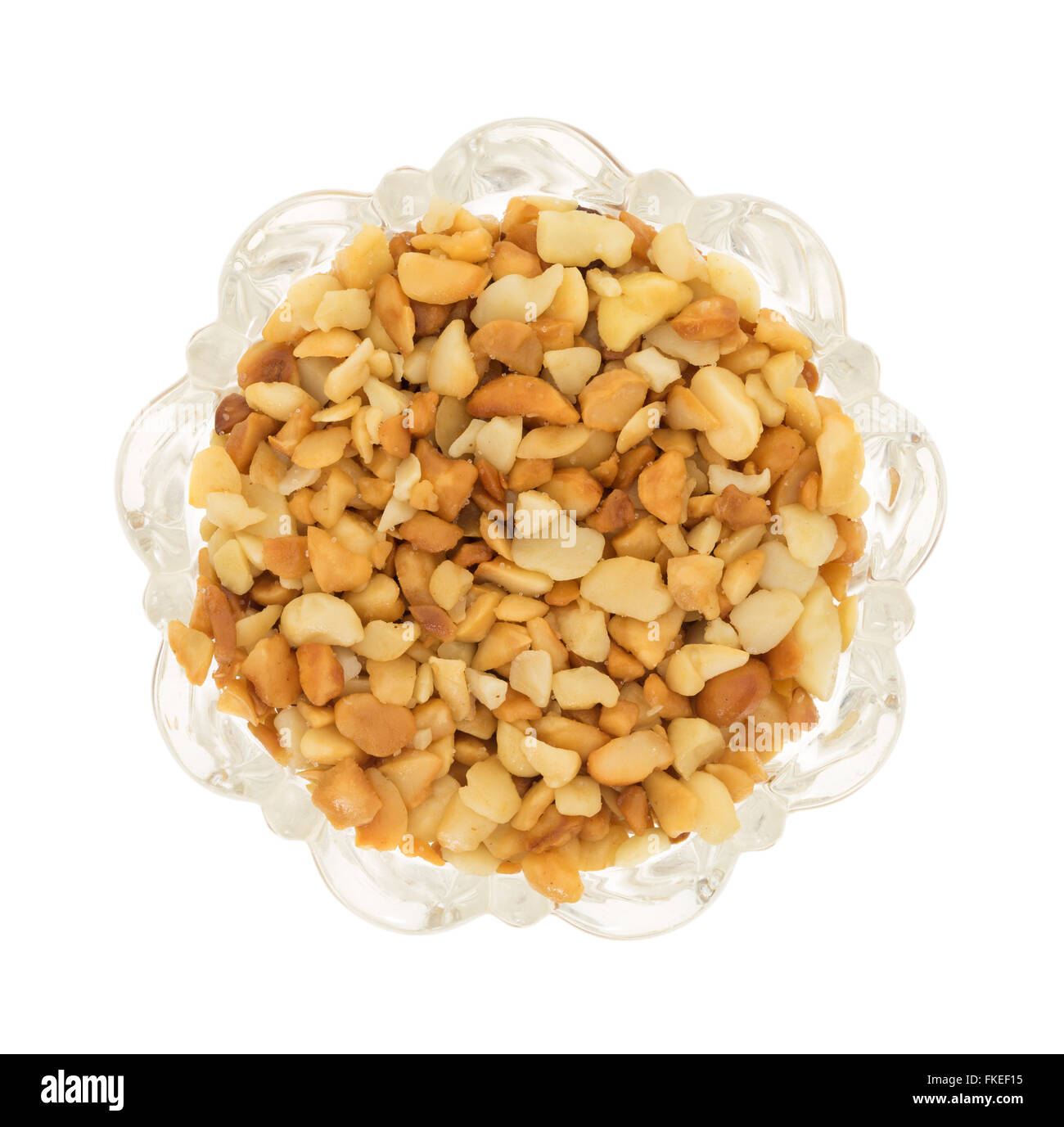 Top view of roasted and salted macadamia nut pieces in a glass bowl ...