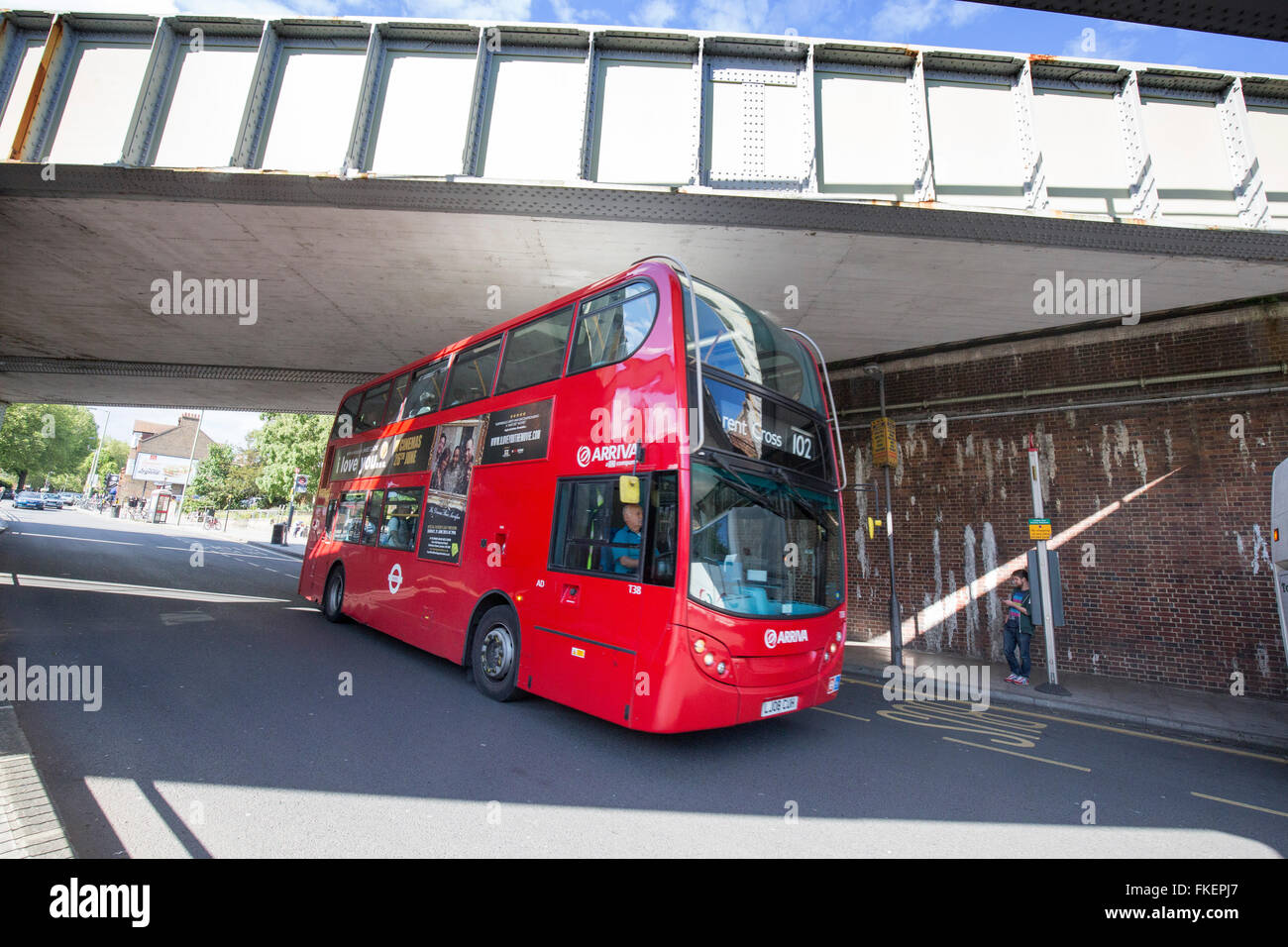 Red Routemaster bus going under railway bridge Stock Photo - Alamy