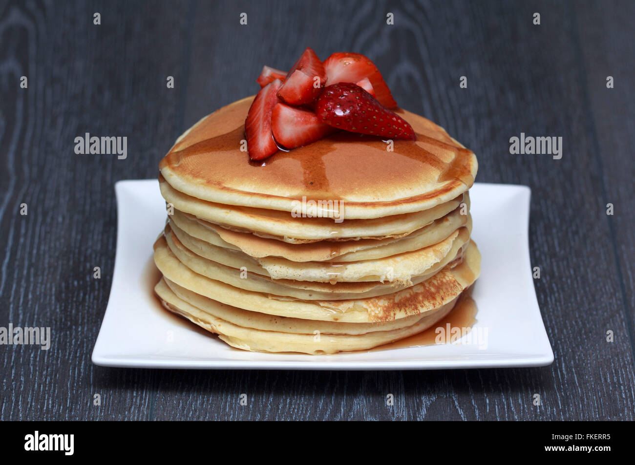 Stack of pancakes with strawberry on dark wooden background Stock Photo ...