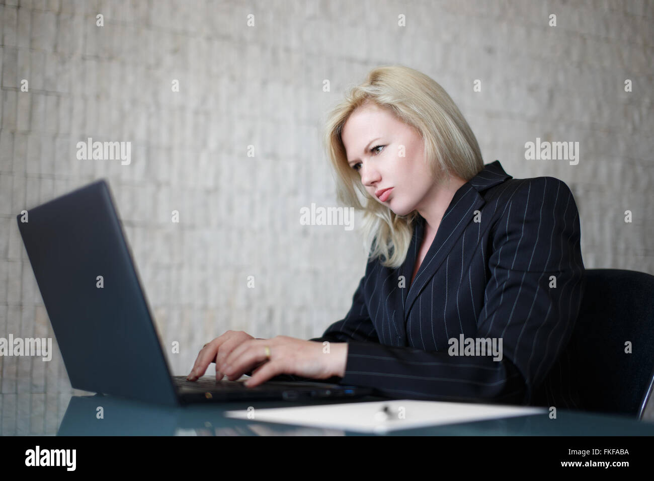 Depressed businesswoman typing on laptop in office Stock Photo - Alamy