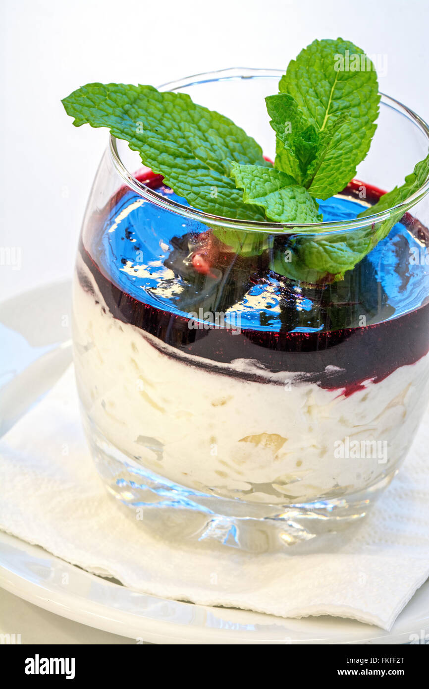 sweet rice cream desert with raspberry sauce and mint on white ...