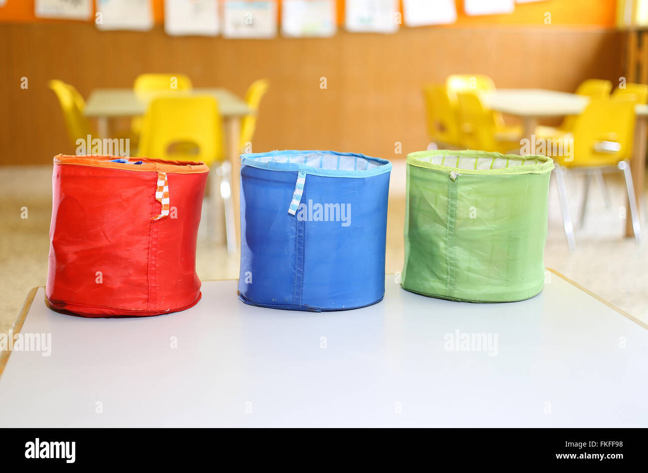 three colored fabric containers for children's toys in the kindergarten ...