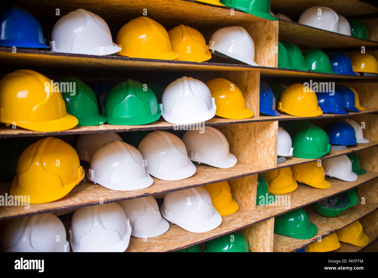 Yellow, white, blue and green safety helmet Stock Photo - Alamy