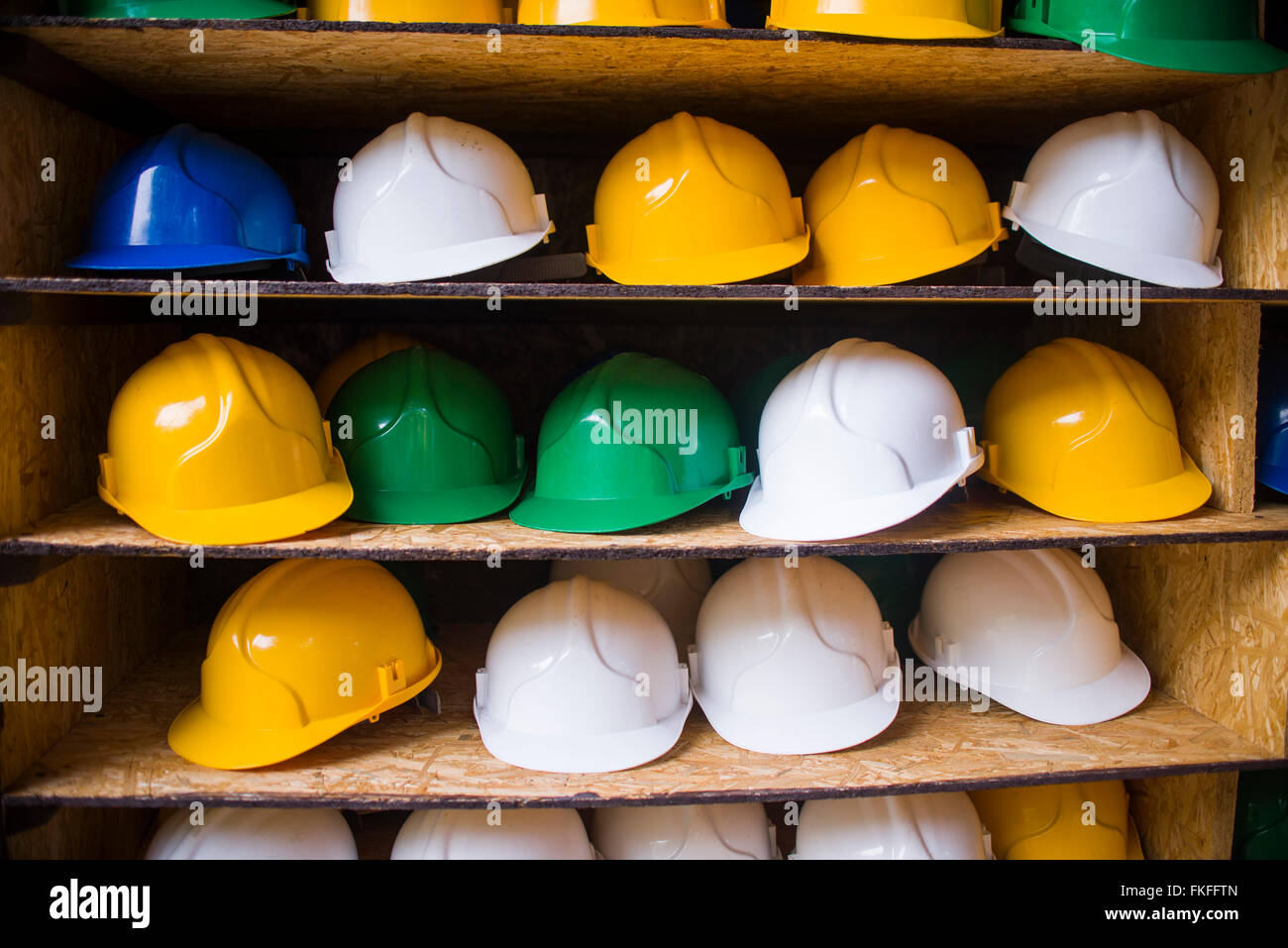 Yellow, white, blue and green safety helmet Stock Photo - Alamy