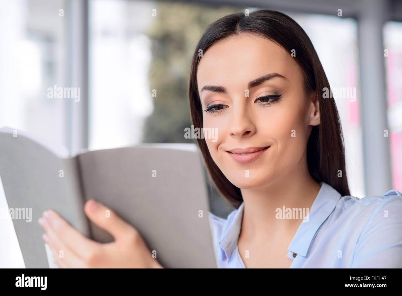 Nice pleasant woman reading book Stock Photo - Alamy
