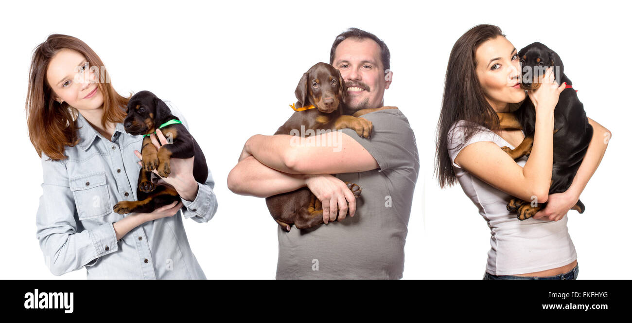 Young family is holding his sweet doberman puppies isolated on white ...