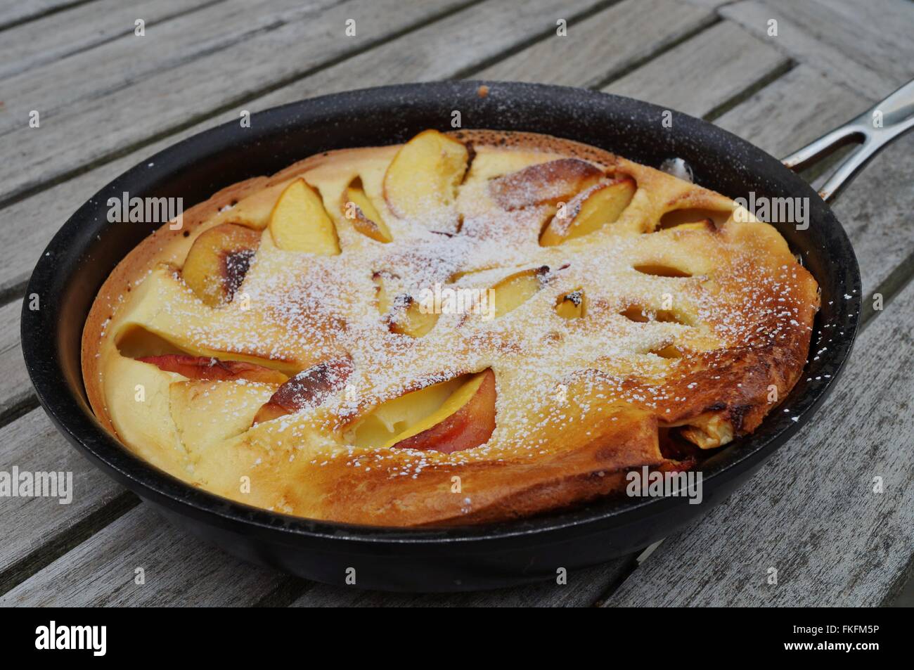Peach Dutch pancake in a pan with powdered sugar Stock Photo - Alamy