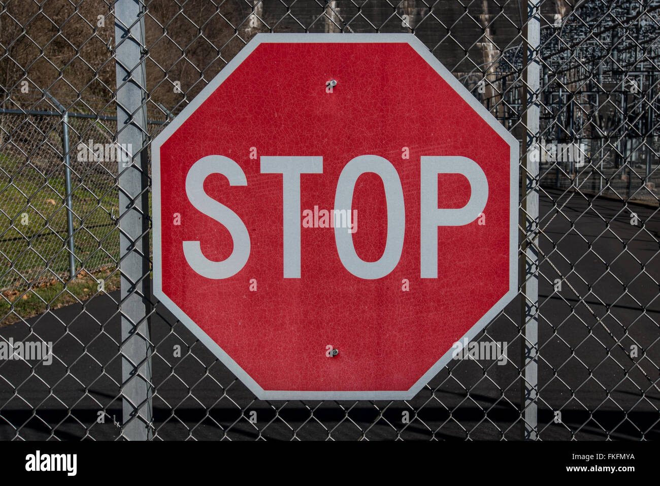 Stop sign on chainlink gate at a water power plant Stock Photo - Alamy