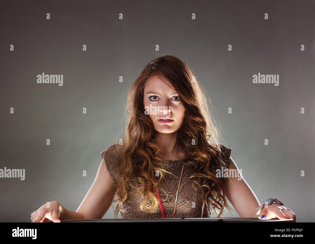 Portrait of mysterious enigmatic woman in studio on grey. Young ...
