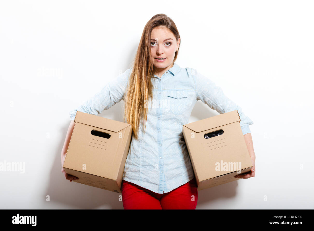 Happy woman moving in carrying cartons boxes. Young girl arranging ...