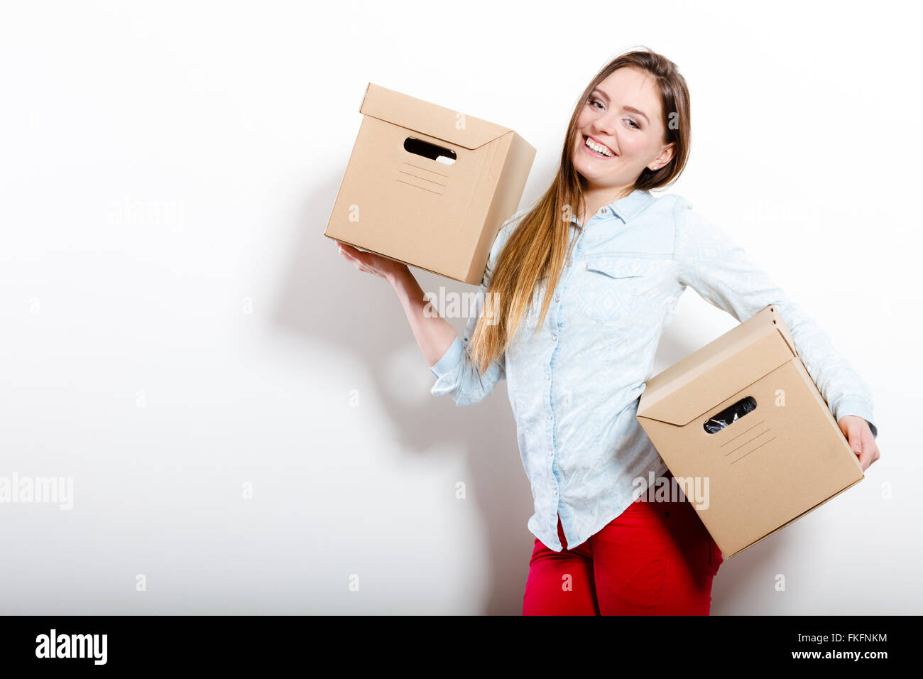 Happy woman moving in carrying cartons boxes. Young girl arranging ...