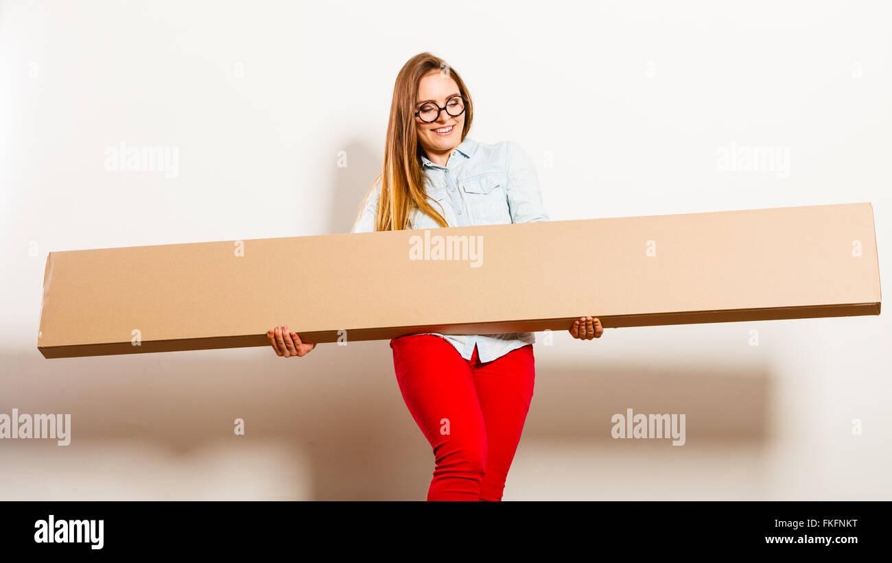 Happy woman moving into new apartment house carrying carton box with ...