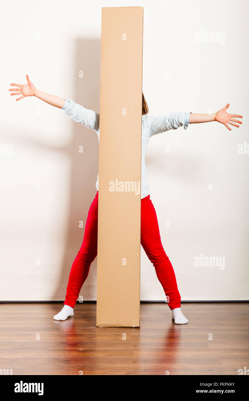 Happy woman moving into new apartment house carrying carton box with ...