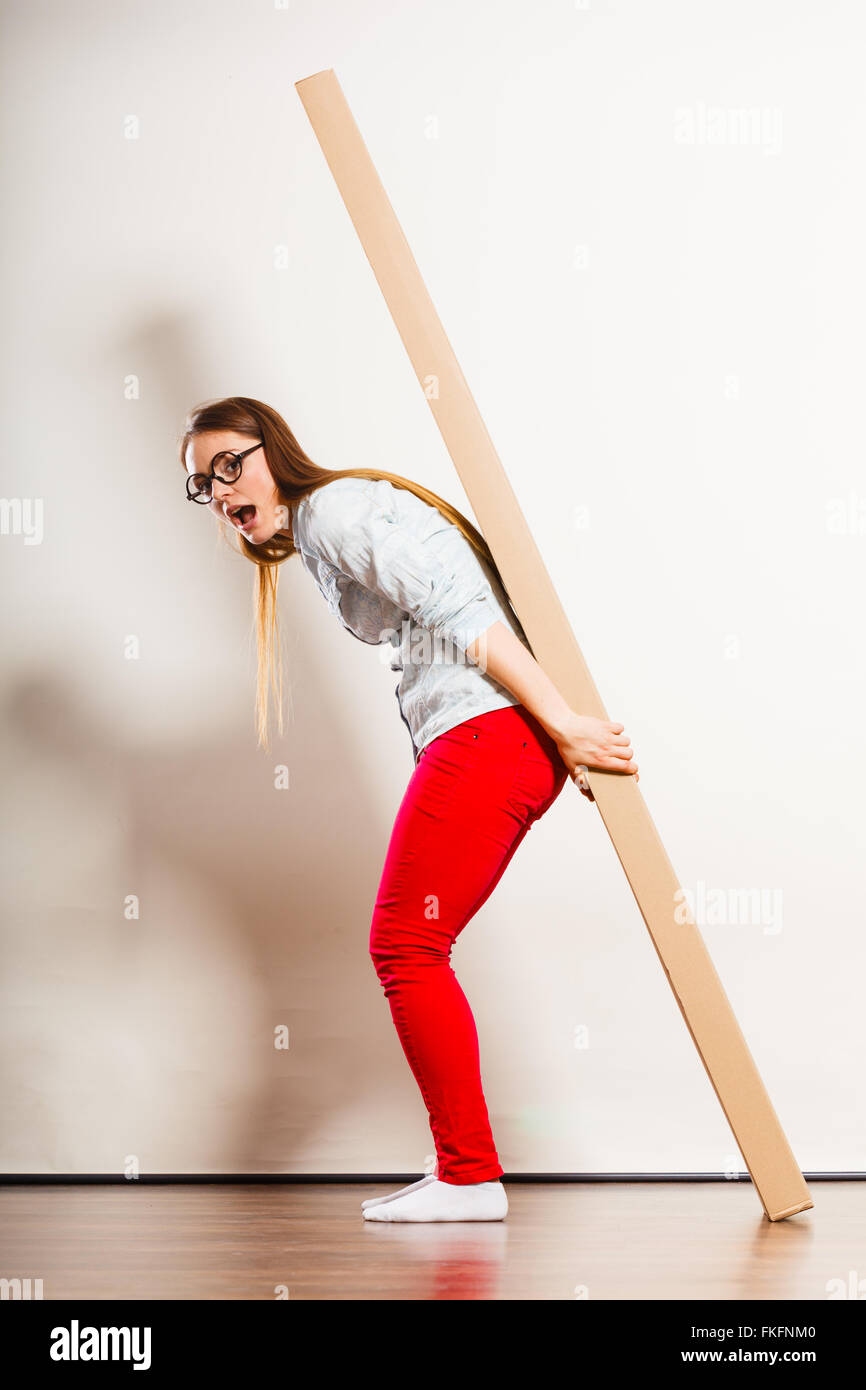 Woman moving into new apartment house carrying heavy carton box with ...