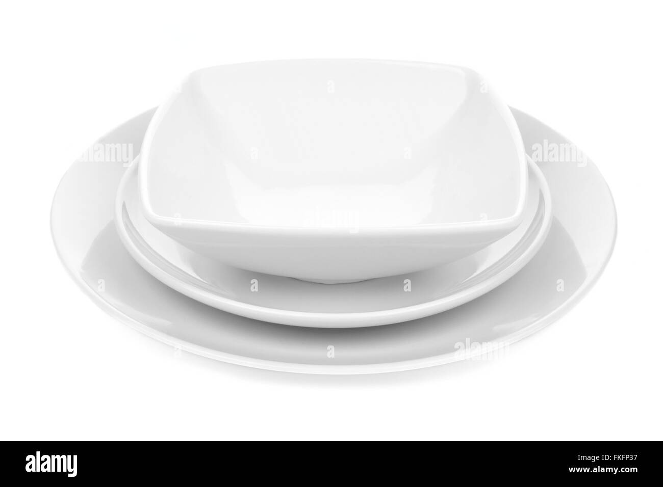 White ceramic dish set with plates and rounded square bowl isolated on ...