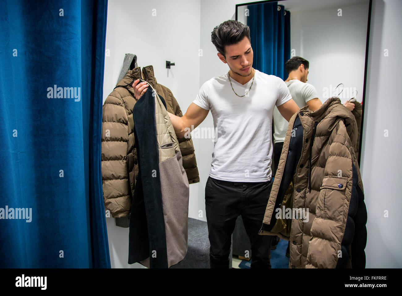 Young Handsome Man Trying on Clothes in Clothing Store's Changing Room ...