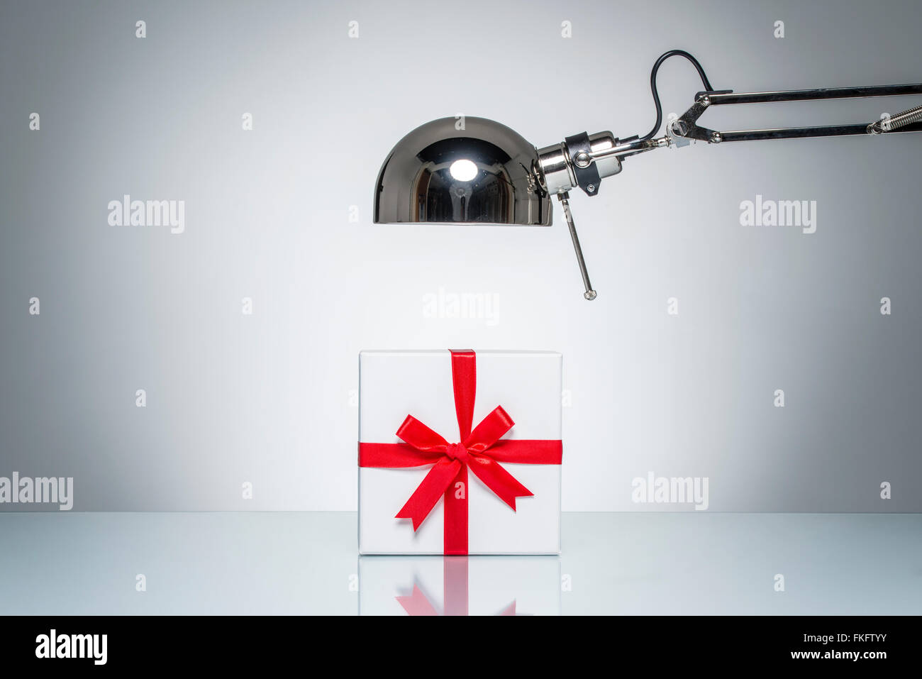 lighting up gift box present with desk lamp on round studio lighting ...