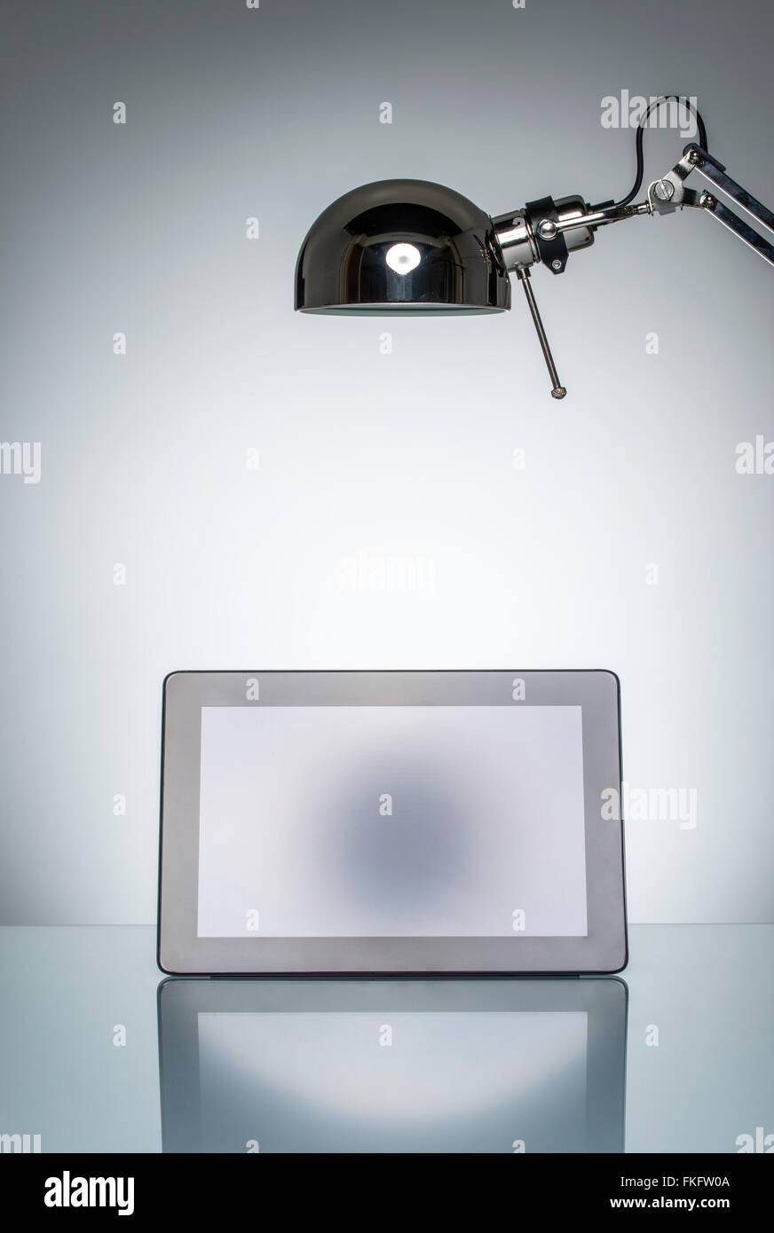lighting up tablet touchpad note with desk lamp on round studio ...