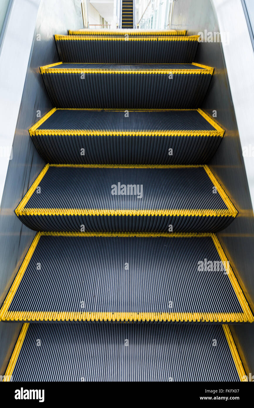 Close focus onto the moving black and yellow escalator Stock Photo - Alamy