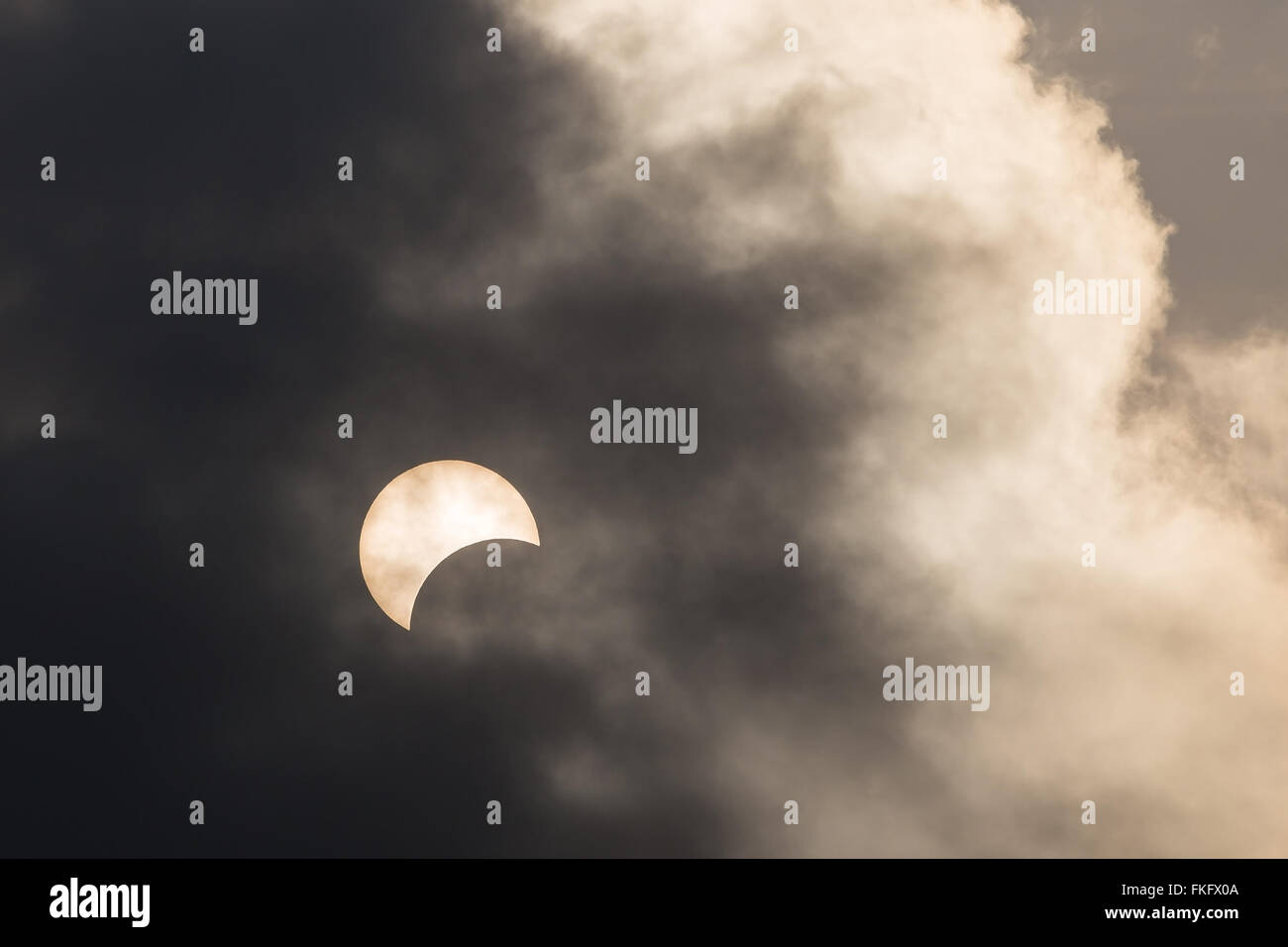 Partial sun eclipse (around 41 percent) behind dark cloude in Bangkok ...