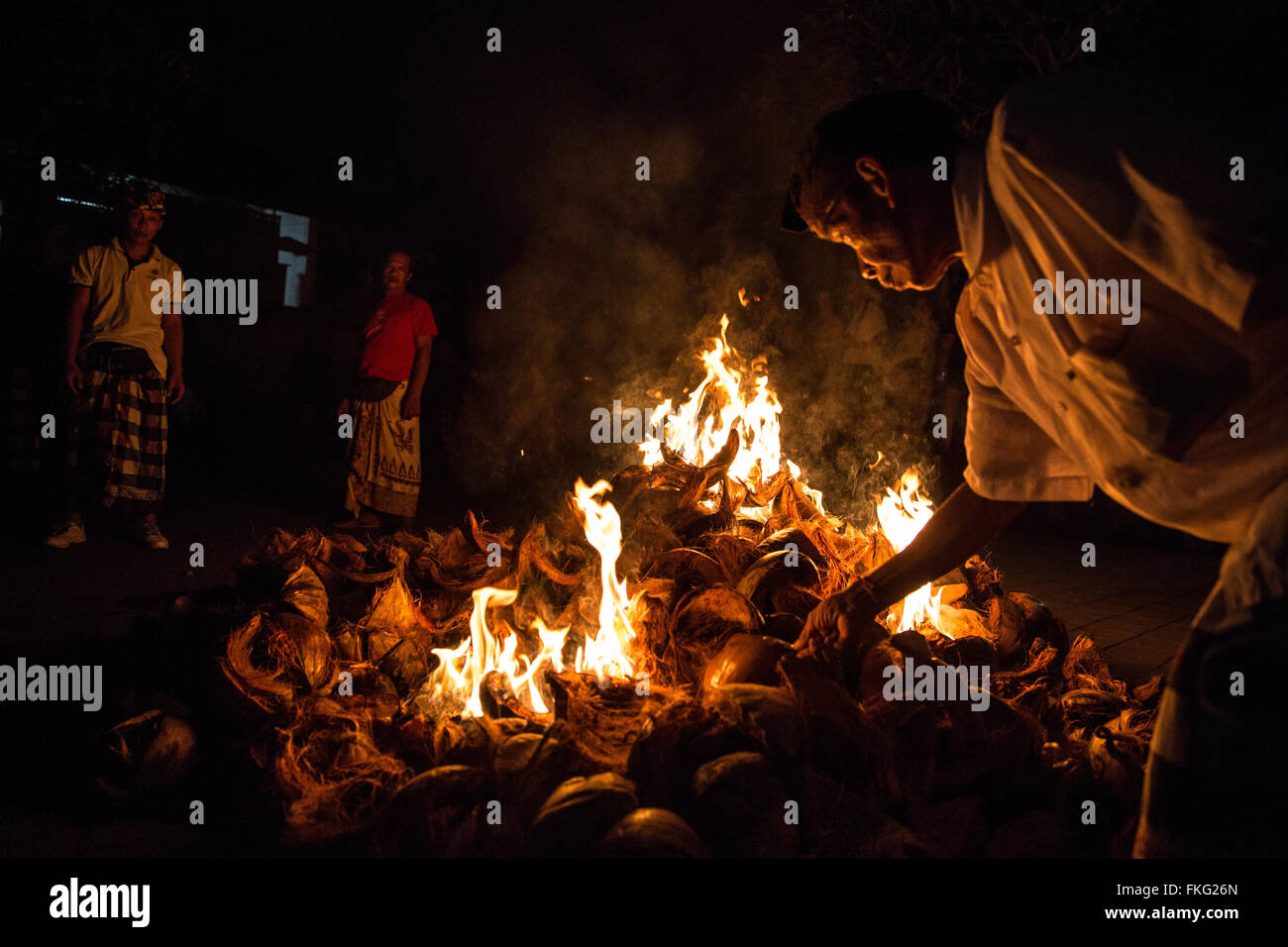 Bali, Indonesia. 08th Mar, 2016. A Balinese man burns coconut husk as ...