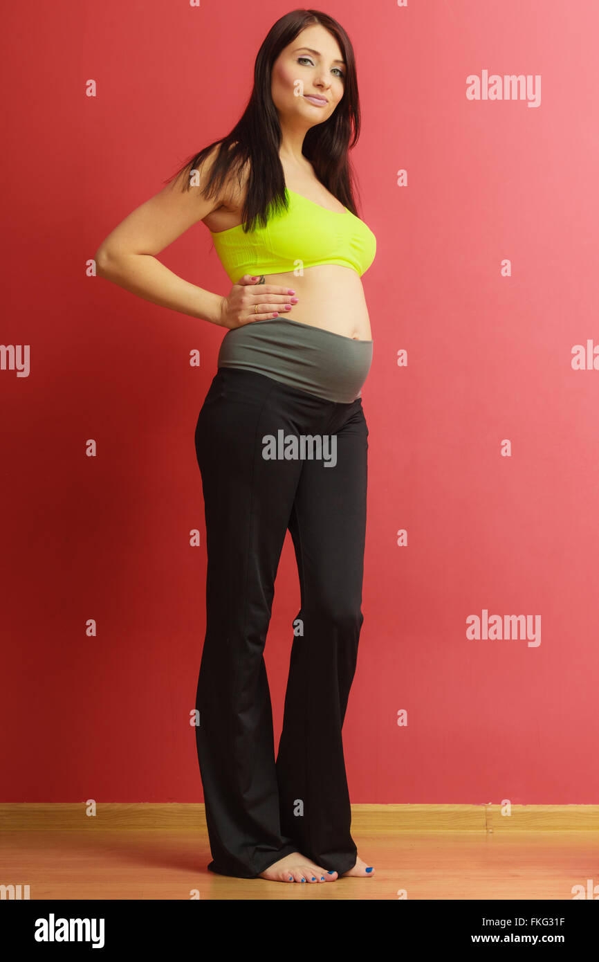 Happiness and motherhood concept. Pregnant fit woman in sportwear on ...