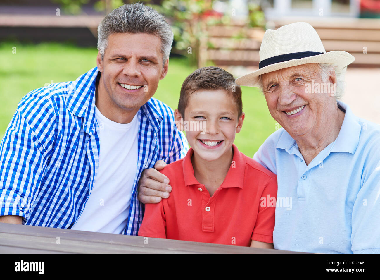 Portrait of male generations sitting together and smiling Stock Photo ...