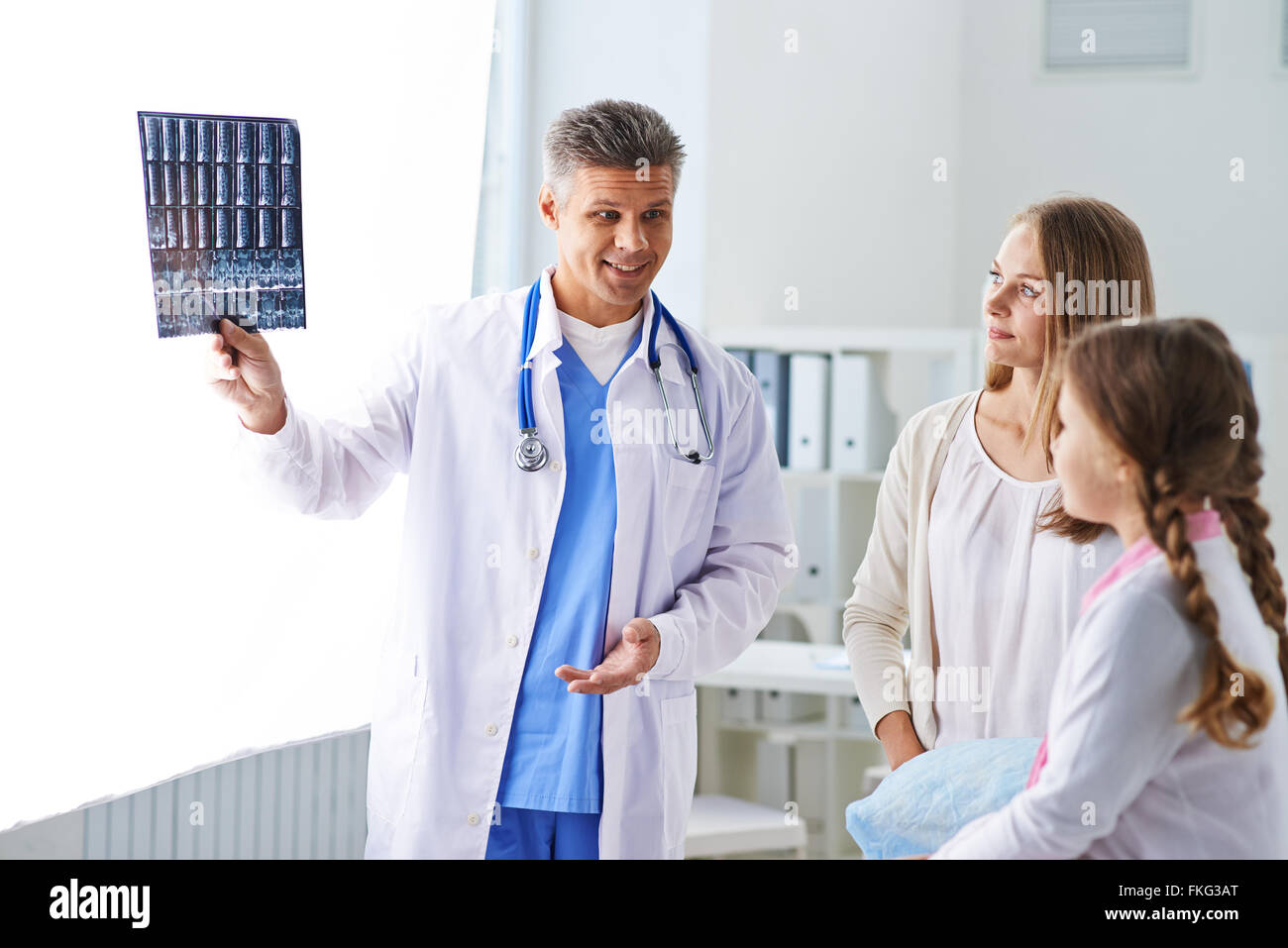 Male pediatrician explaining X-ray to child and her mom Stock Photo - Alamy