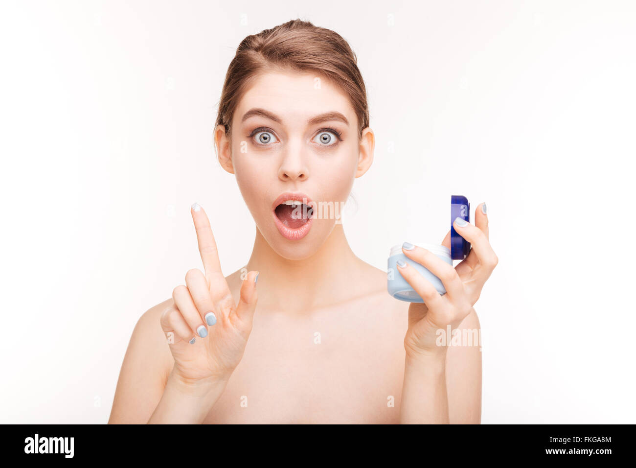 Amazed woman holding facial cream isolated on a white background Stock ...
