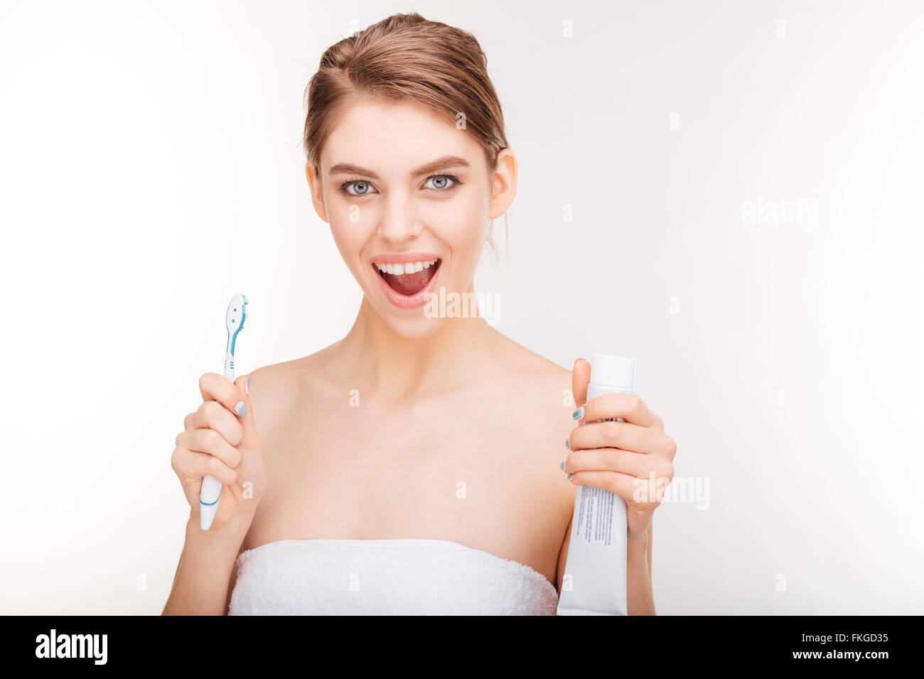 Beauty portrait of joyful charming young woman holding toothpaste and ...