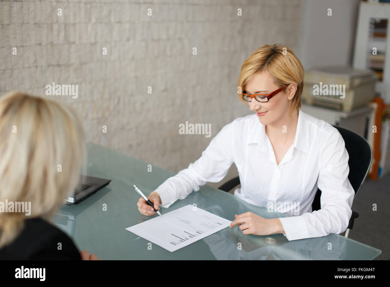 Blonde businesswoman fill out a form in office Stock Photo - Alamy