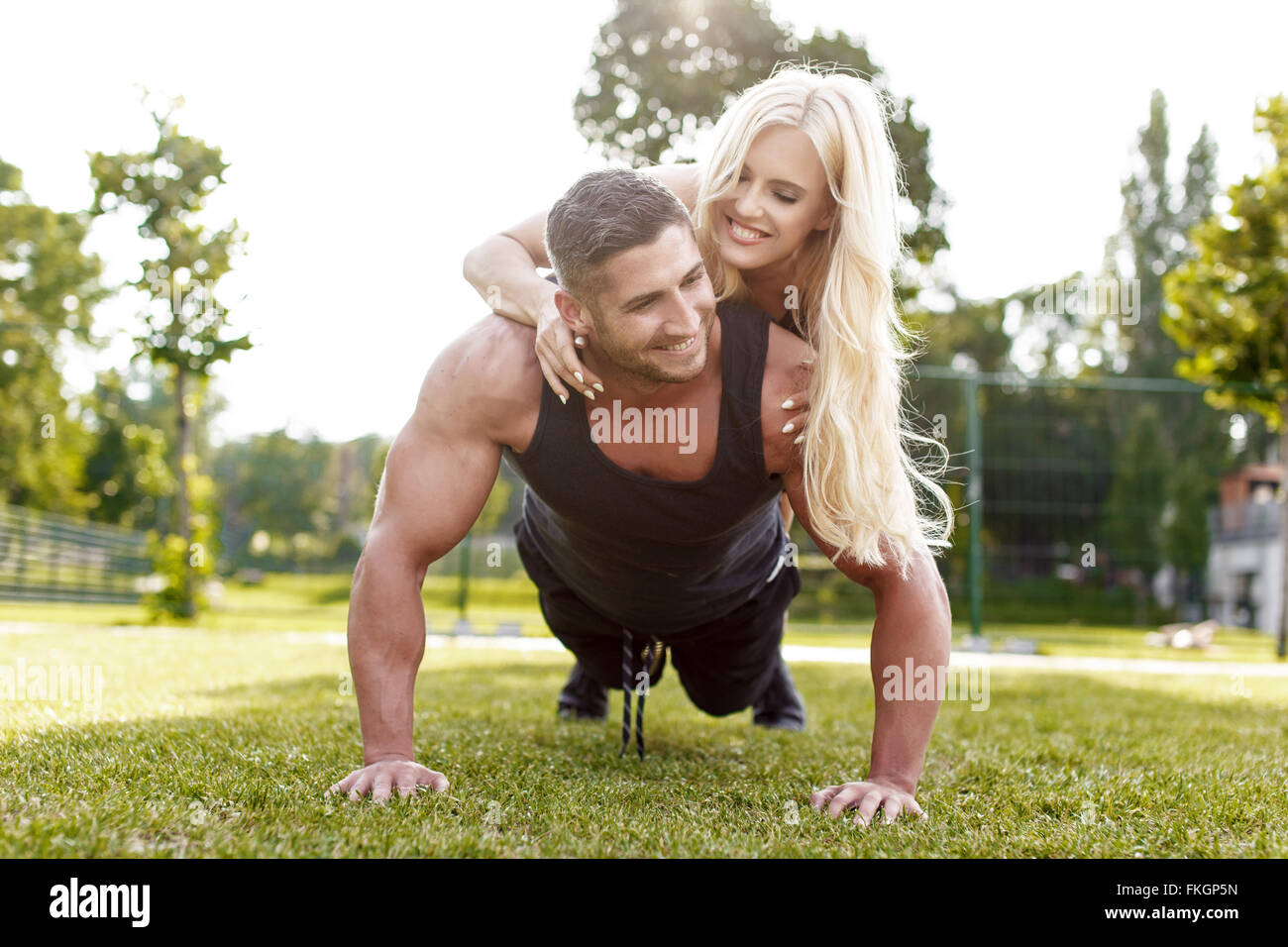 Man doing push-ups with woman on back, healthy couple, workout with own ...