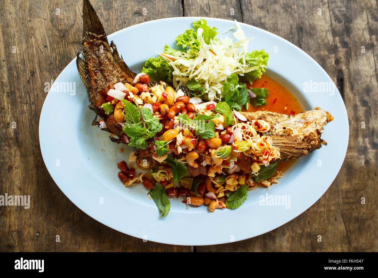 deep fried fish with herb and spicy sauce, thai food Stock Photo - Alamy