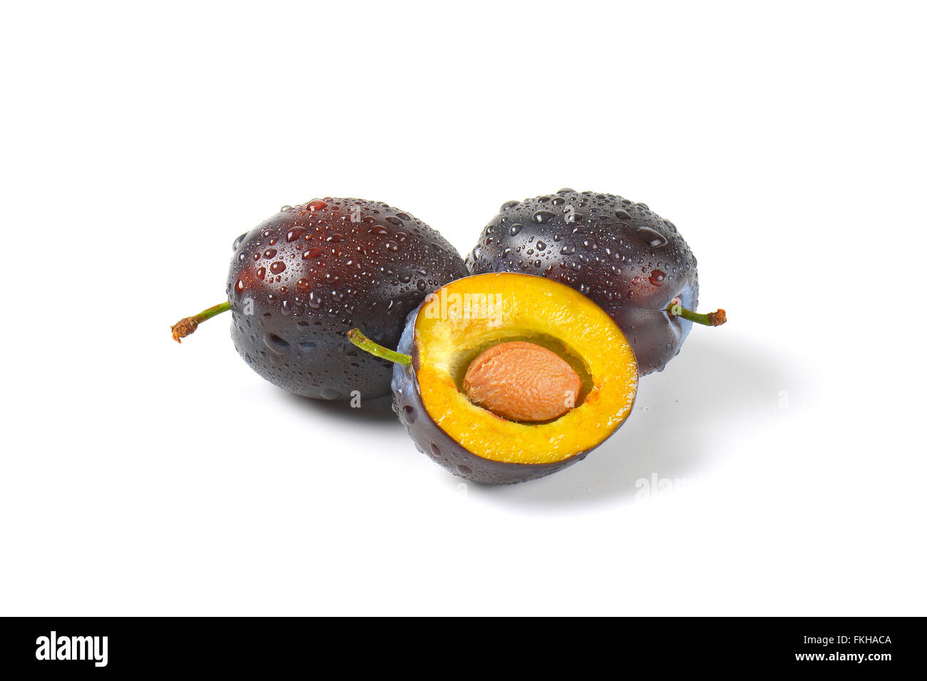two and half washed plums on white background Stock Photo - Alamy