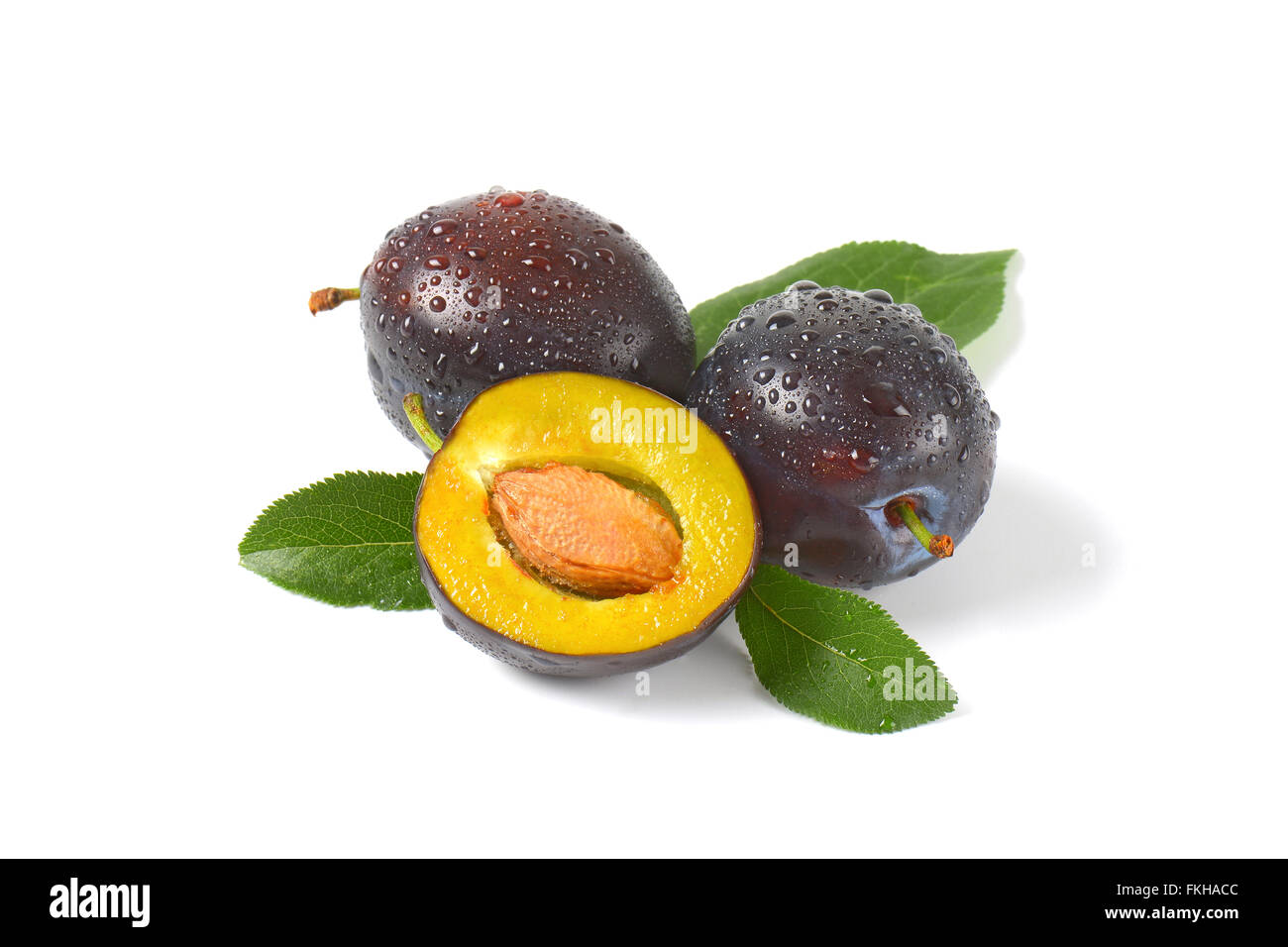two and half washed plums on white background Stock Photo - Alamy